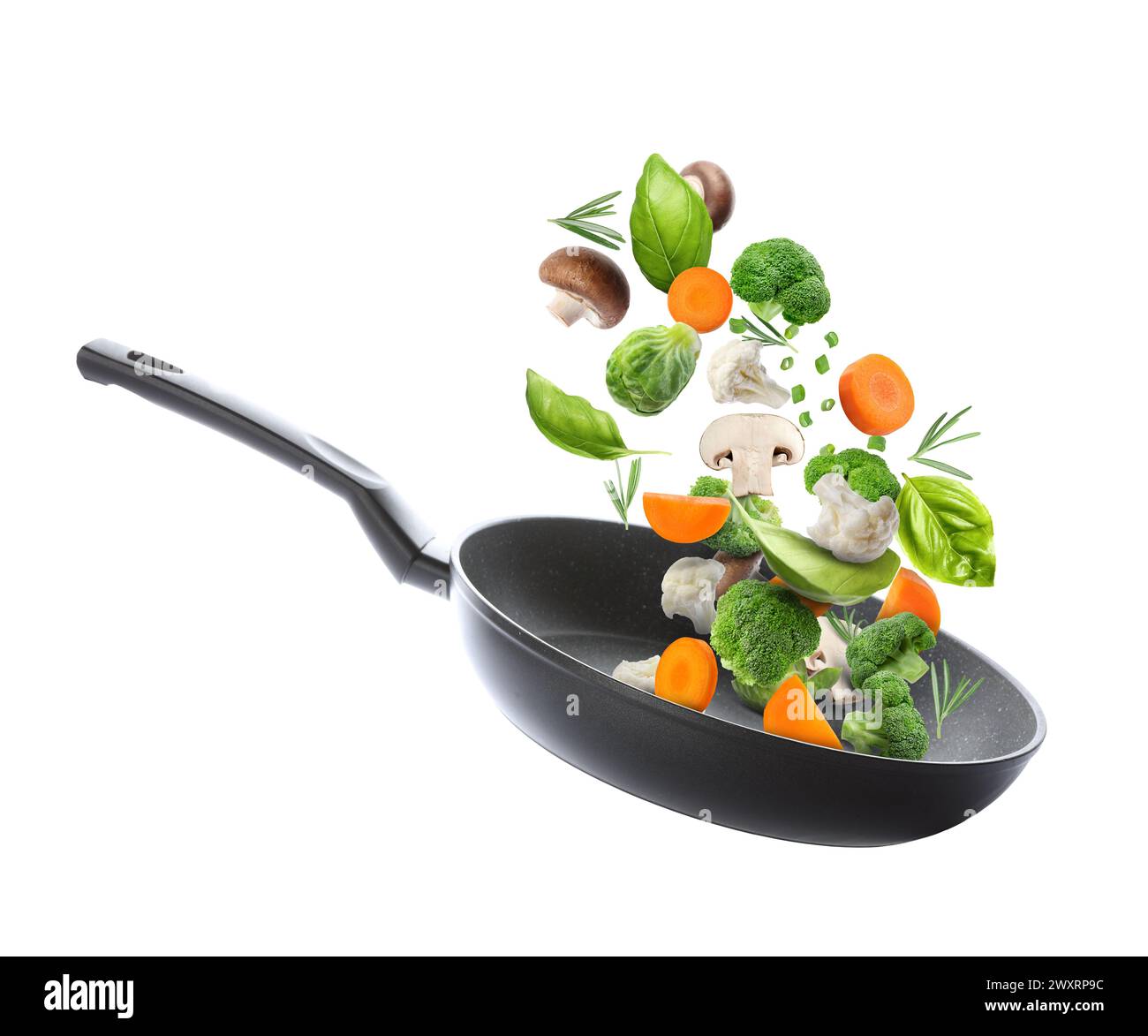 Frying pan with fresh ingredients in air on white background Stock ...
