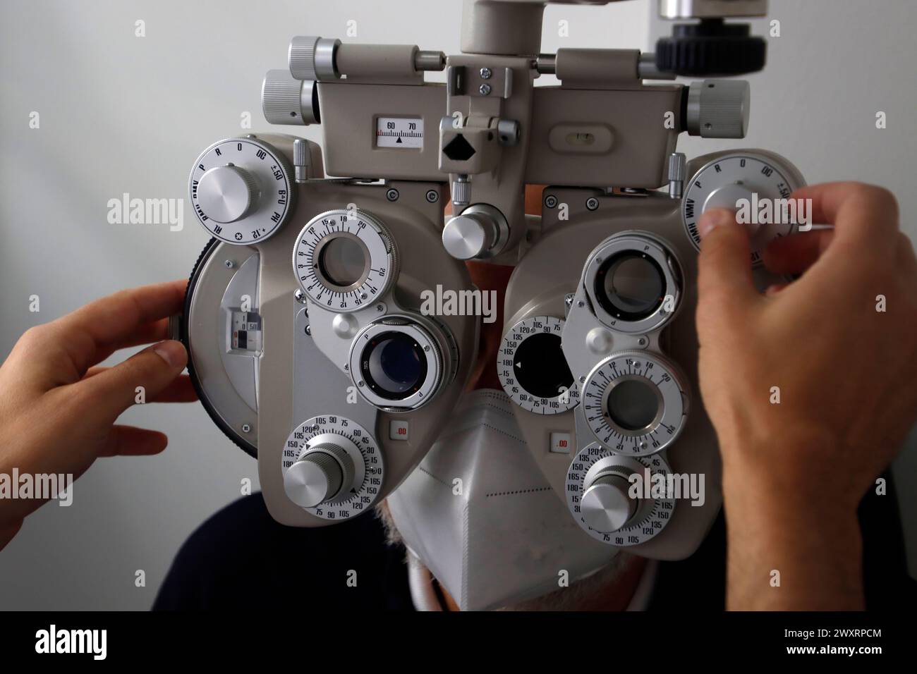 An ophthalmologist uses eyepiece to examine patient's eyes Stock Photo ...