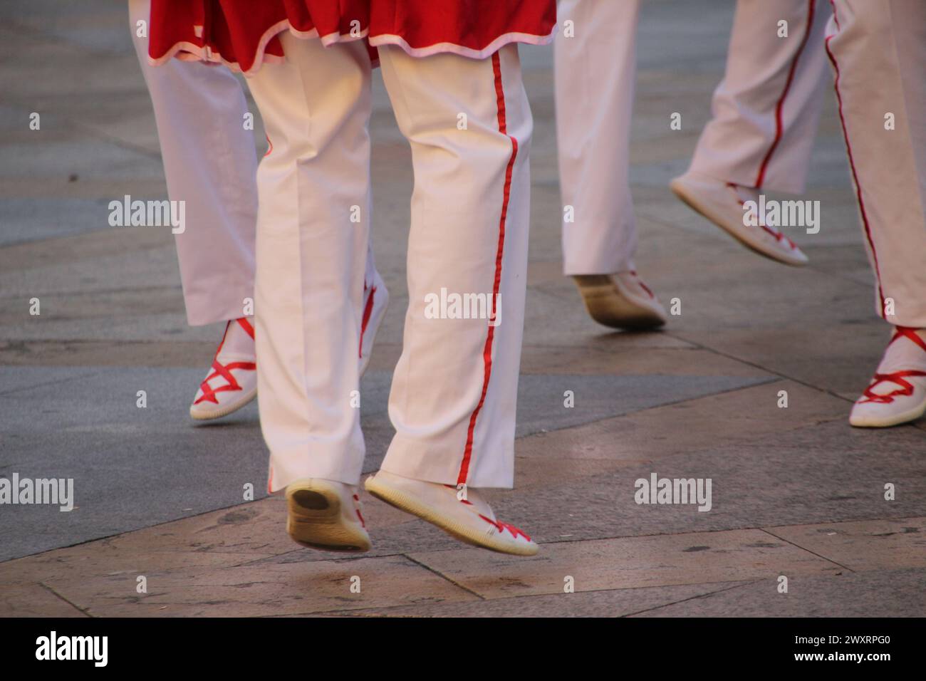 A diverse group of Basque folk dancers during a festival in the street ...