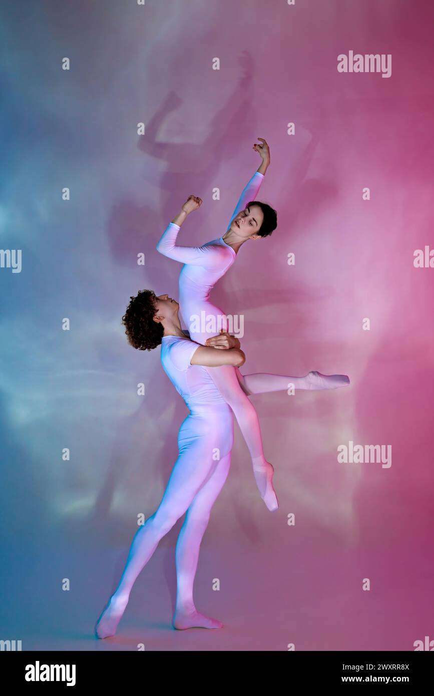 Modern ballet duo mid-performance, male dancer lifting female dancer ...