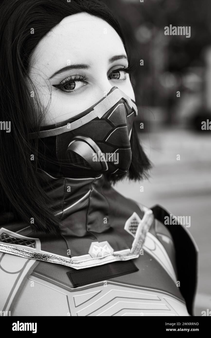 A grayscale photo of a cosplayer in front of a brick wall Stock Photo ...