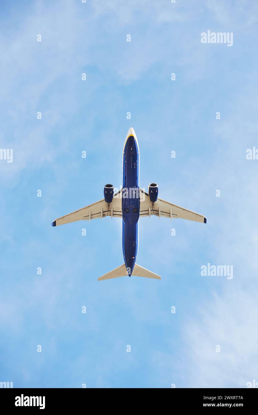 Commercial airplane captured from below as it climbs into the vast blue ...