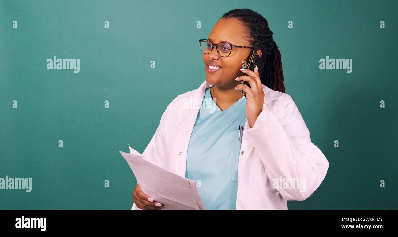Black female doctor talks to patient on cellphone, medical records ...