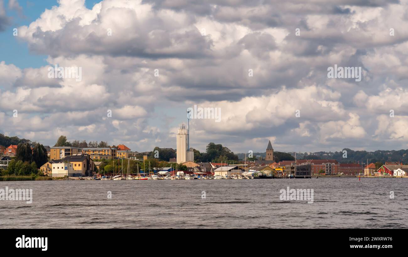 Panoramic view of Hobro skyline with church tower against a cloudy sky ...