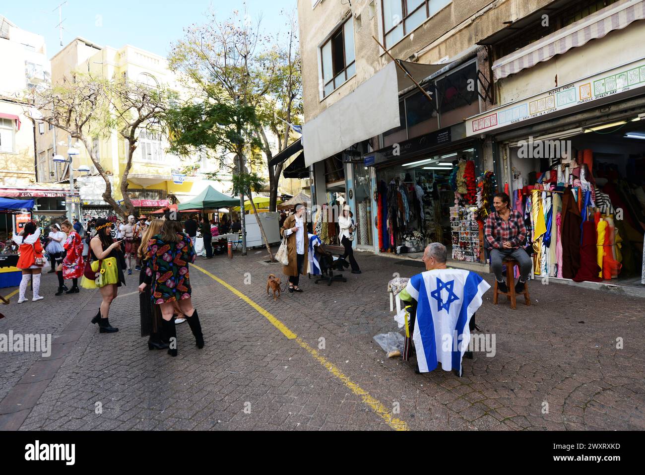Israelis wearing costumes at the Carmel market during Purim festival ...