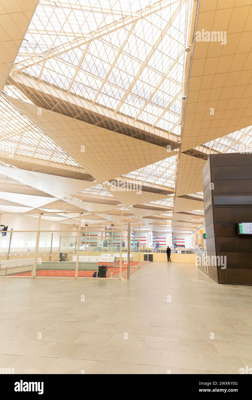 A large open space with a lot of white and brown elements. A person is ...