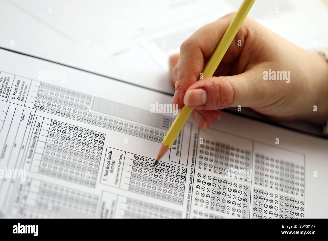 Female student hands testing in exercise and taking fill in exam paper ...