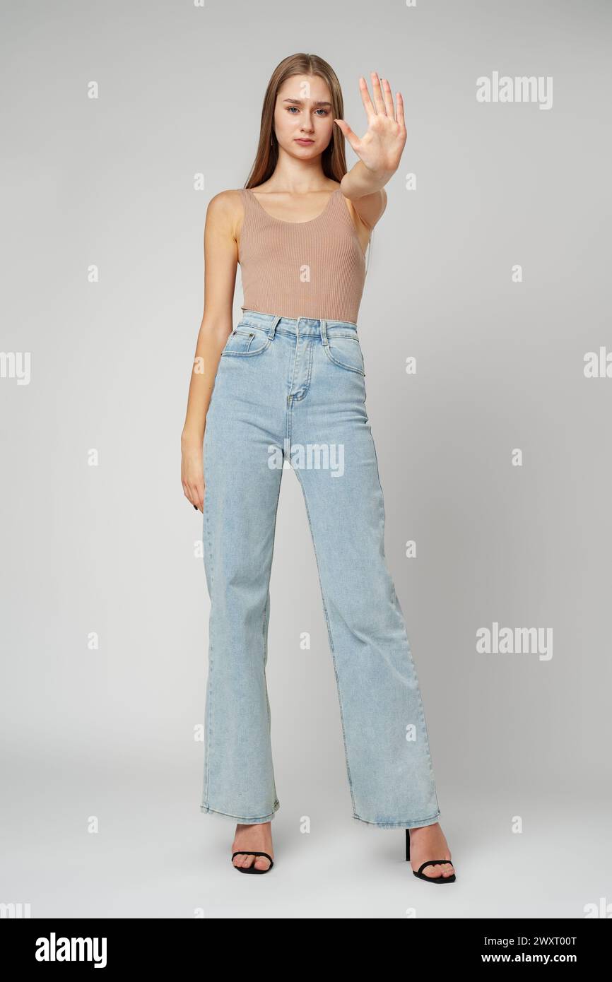 Young Woman in Fashionable Outfit Standing Against a Neutral Backdrop ...