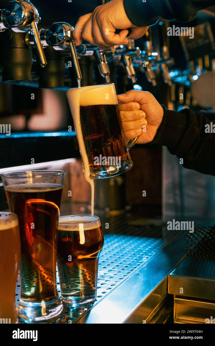 Lineup of different types of beer with new addition being poured by ...