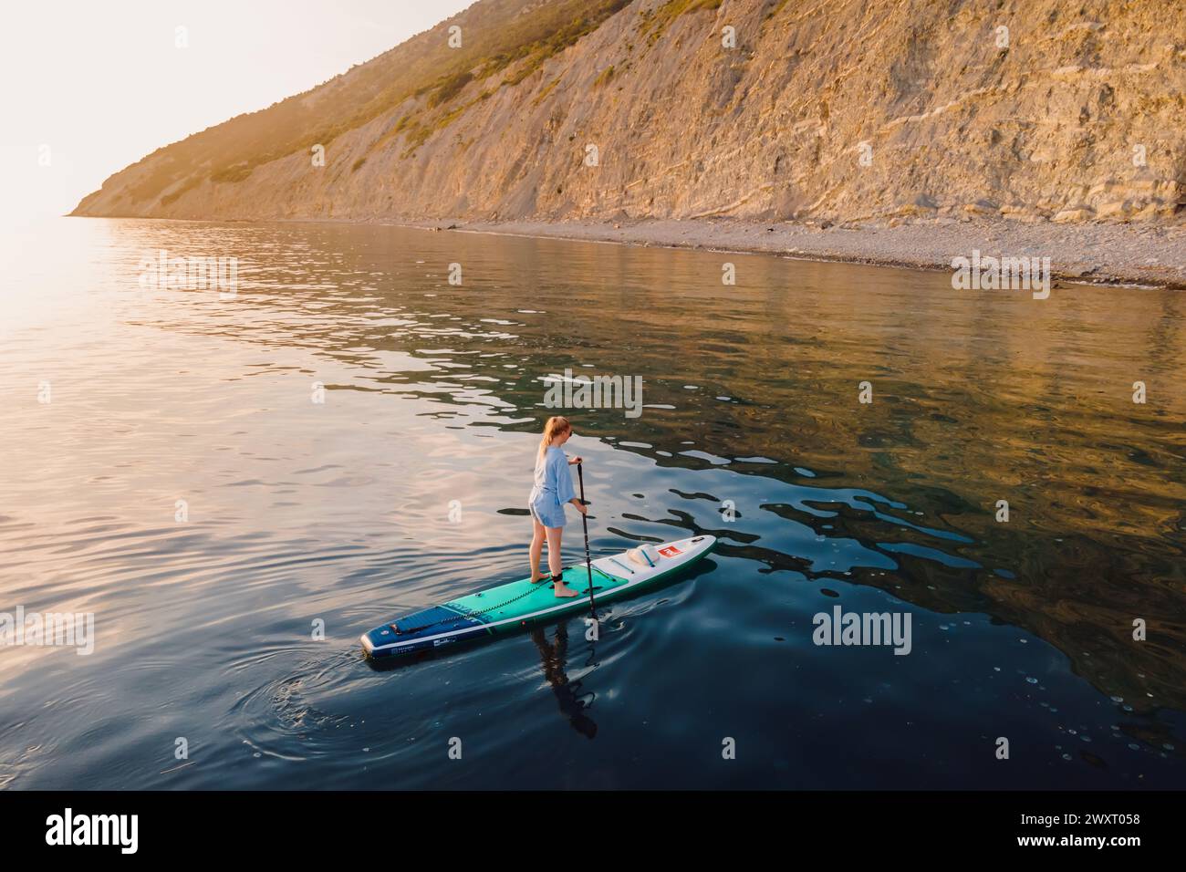 April 28, 2023. Antalya, Turkey. Woman on paddle board at quiet sea in ...