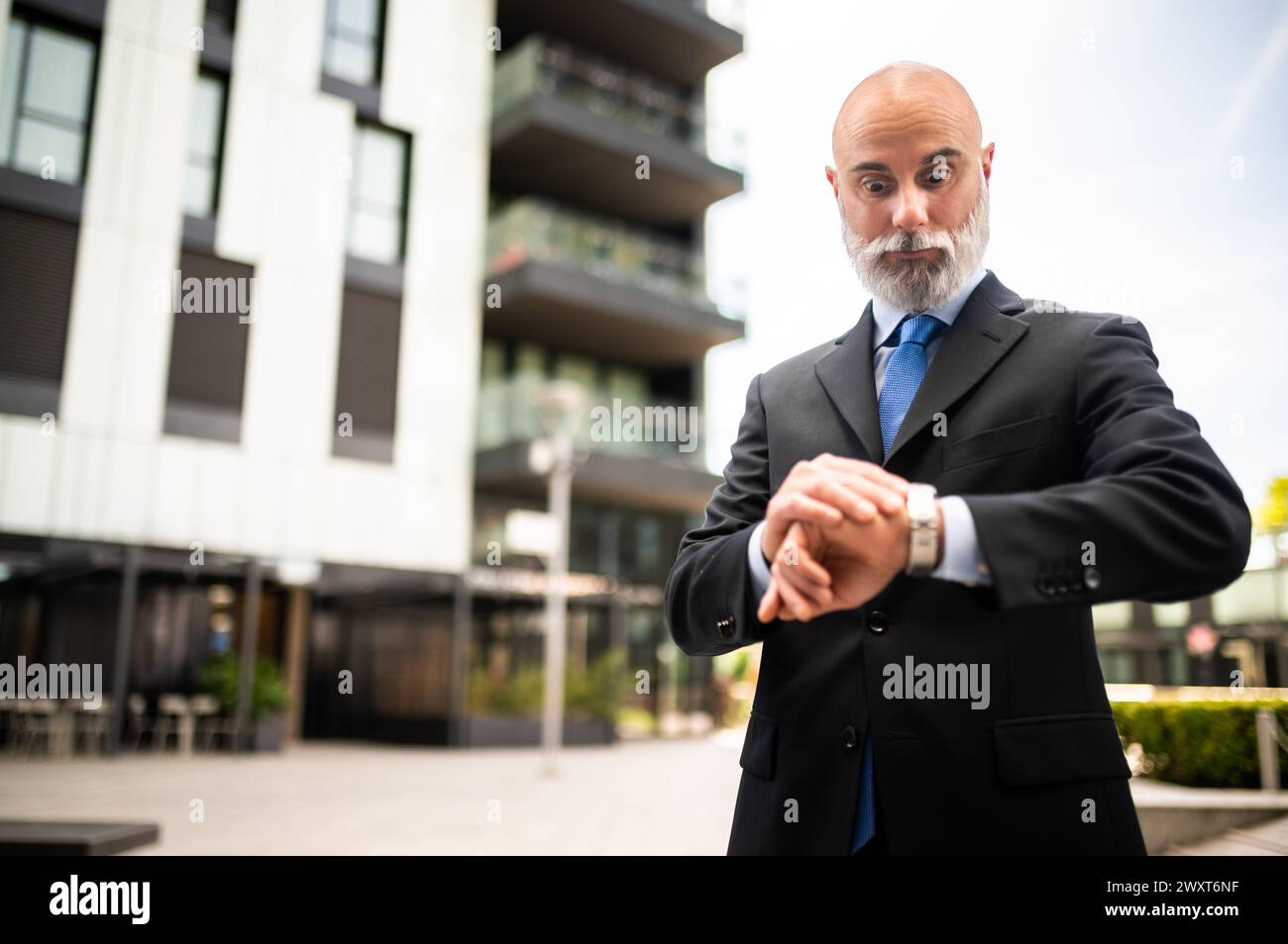 Businessman checking his wrist watch with a shocked expression Stock ...