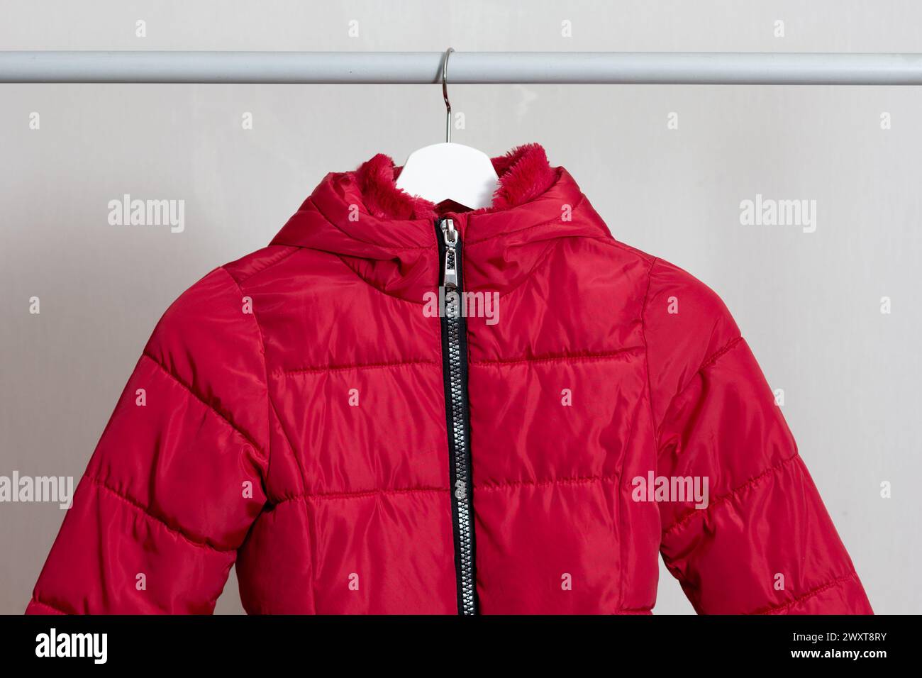 Red child puffer coat hanging Stock Photo - Alamy