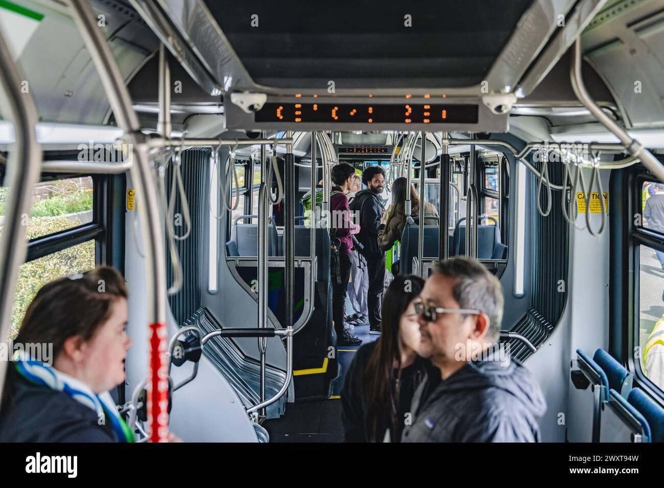 A group of commuters boards the inaugural Swift Orange Line bus ...