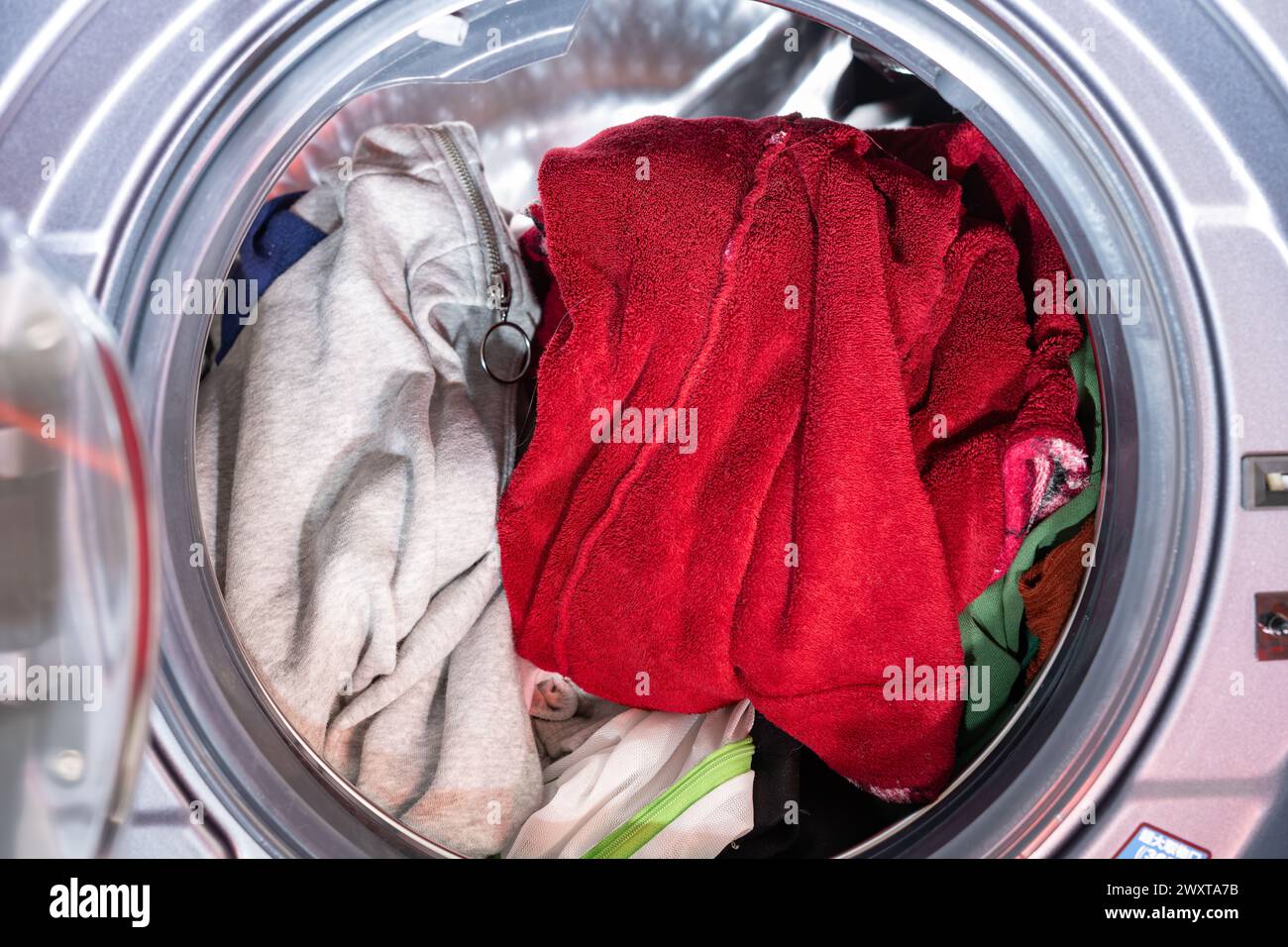 front-loading washing machine filled with clothes and about to start ...