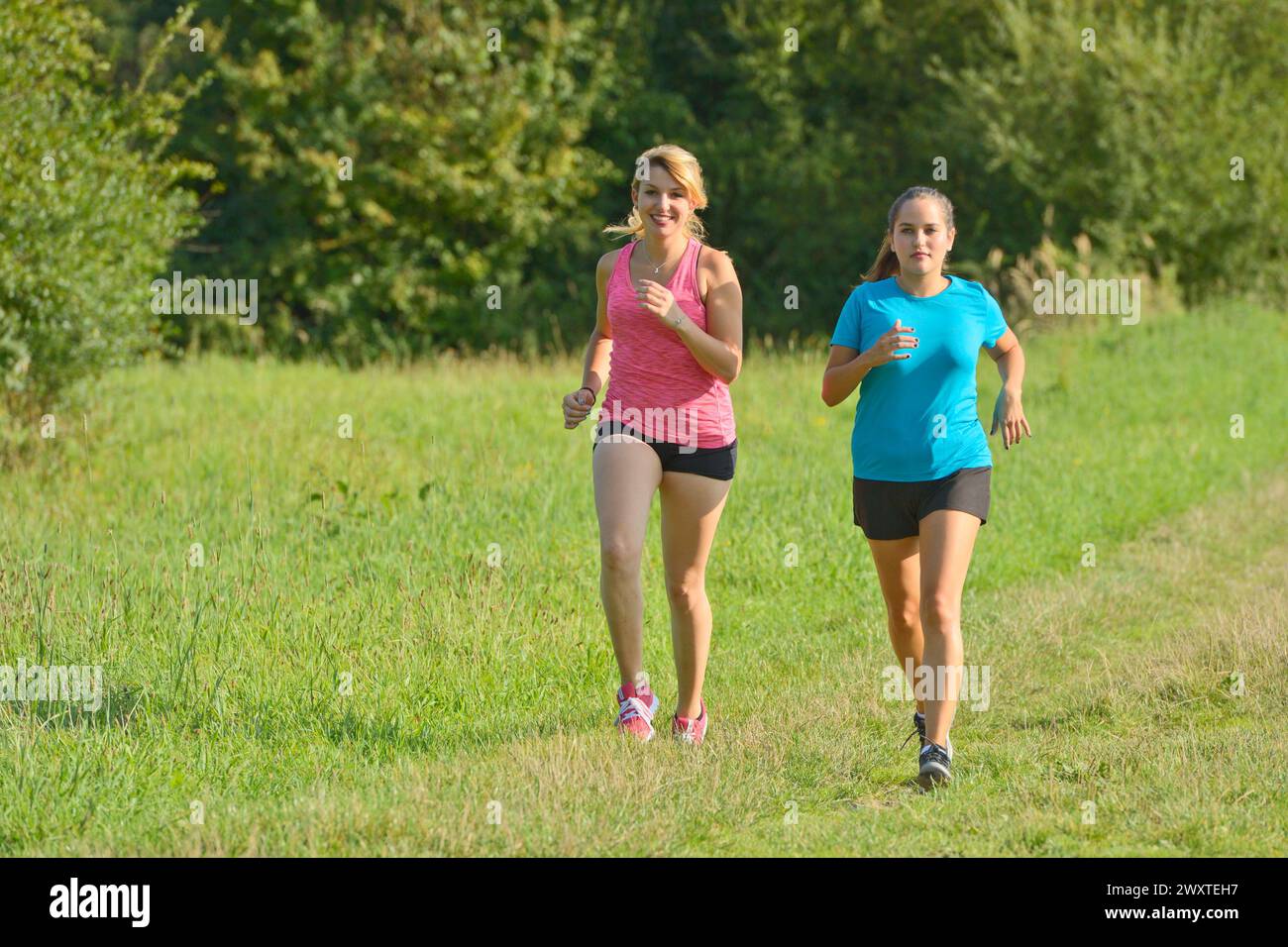 Two young women running Stock Photo - Alamy