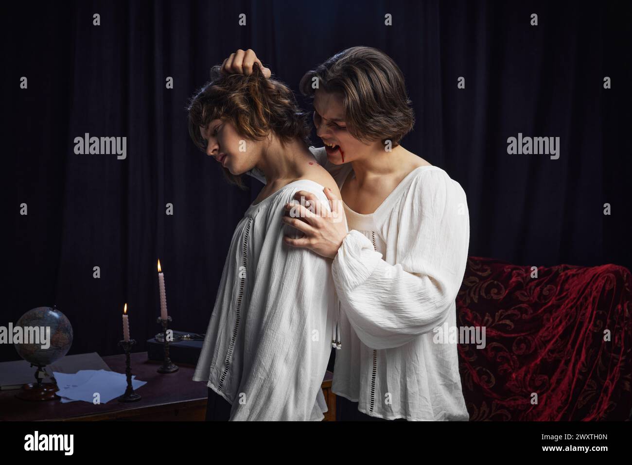Young handsome man grips hair of another, mimicking vampire behavior ...