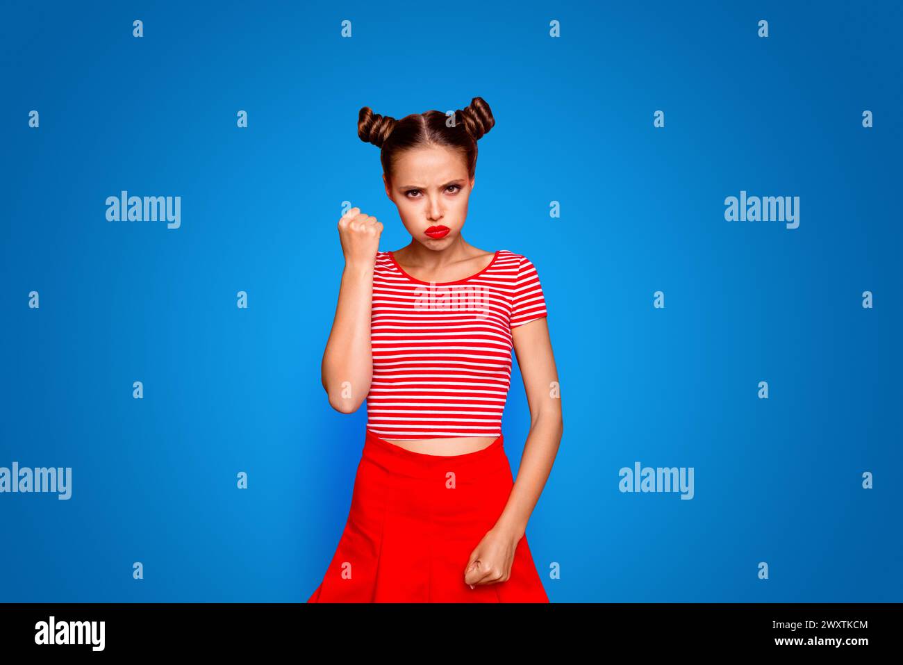 Portrait of grimacing capricious and sad girl model with bun hairstyle ...