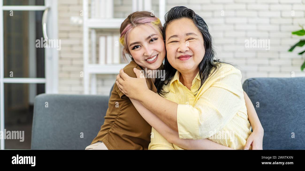 Two women sitting on a couch, embracing and smiling happily Stock Photo ...