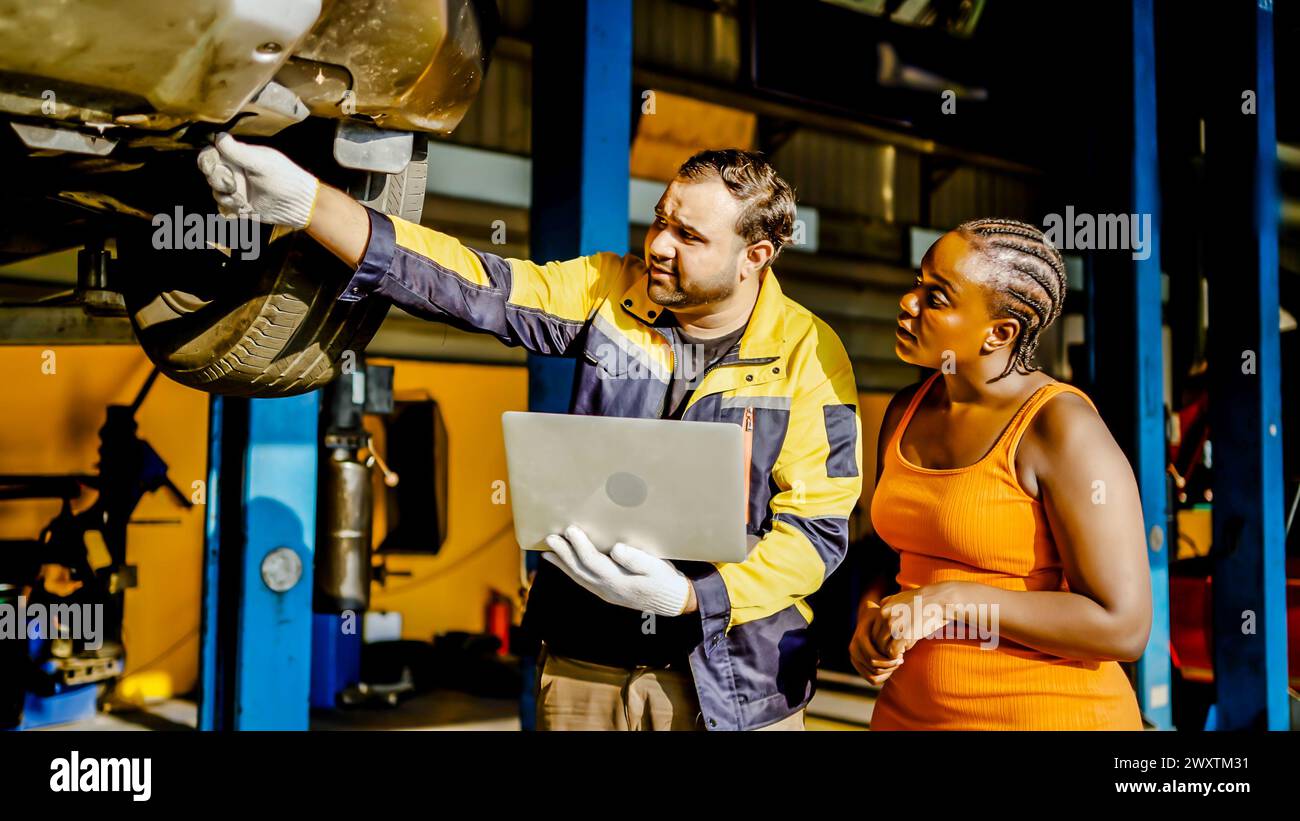 Two mechanics inspecting the underside of a vehicle Stock Photo - Alamy