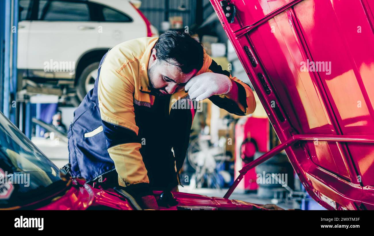 Man in yellow and black working on red car Stock Photo - Alamy