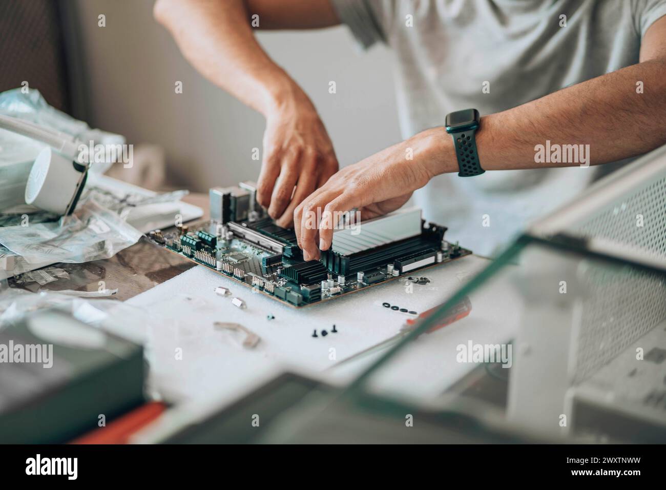Component Connection : A close-up of hands meticulously assembling a desktop's motherboard ...