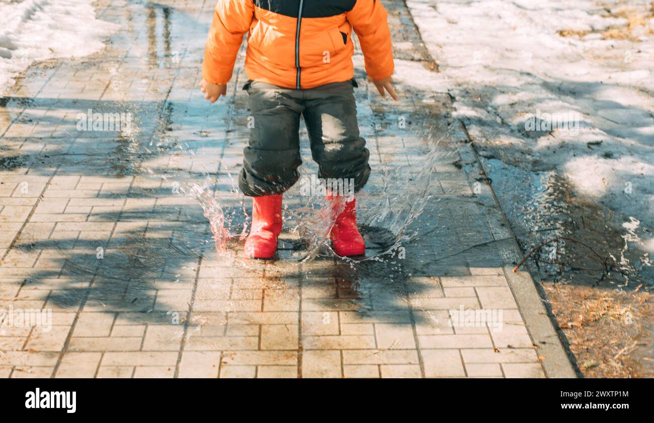 Gleeful Puddles : With every step, the child's red boots send a cascade ...