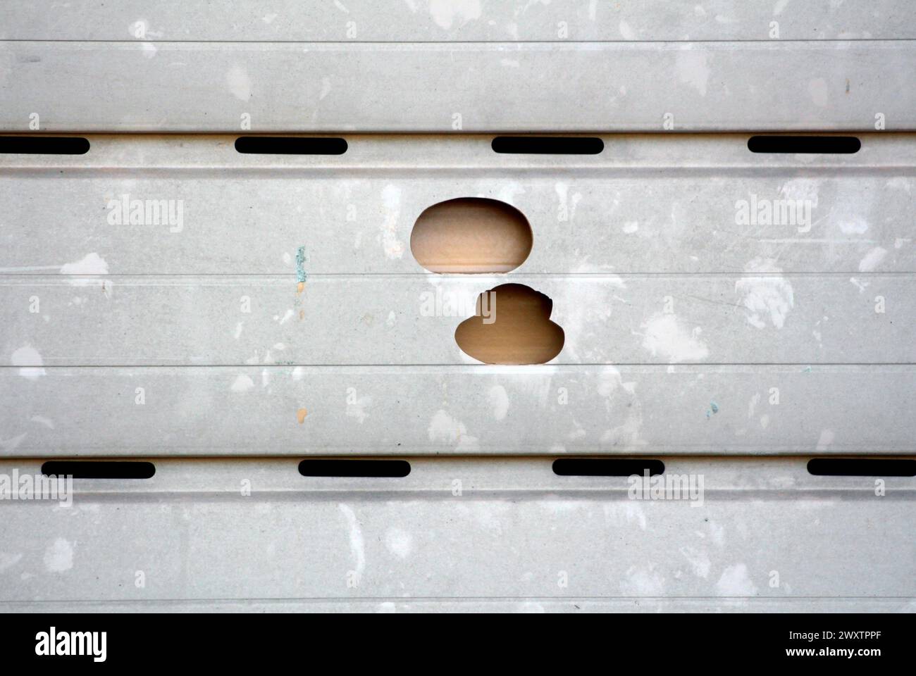 Closeup of two large hail damage holes on family house dirty old ...