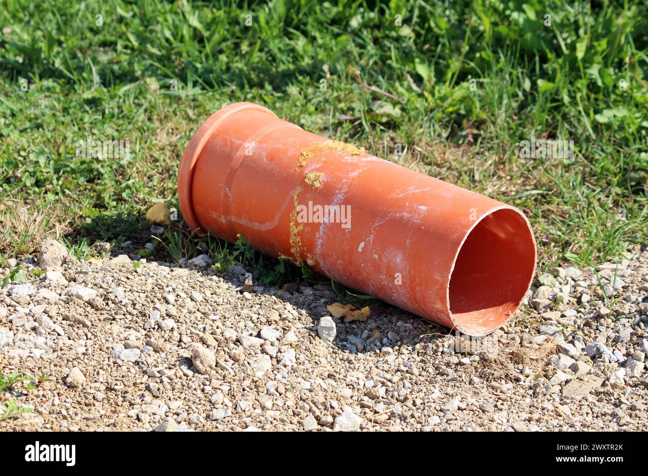 Part of orange PVC large diameter construction pipe covered with yellow ...