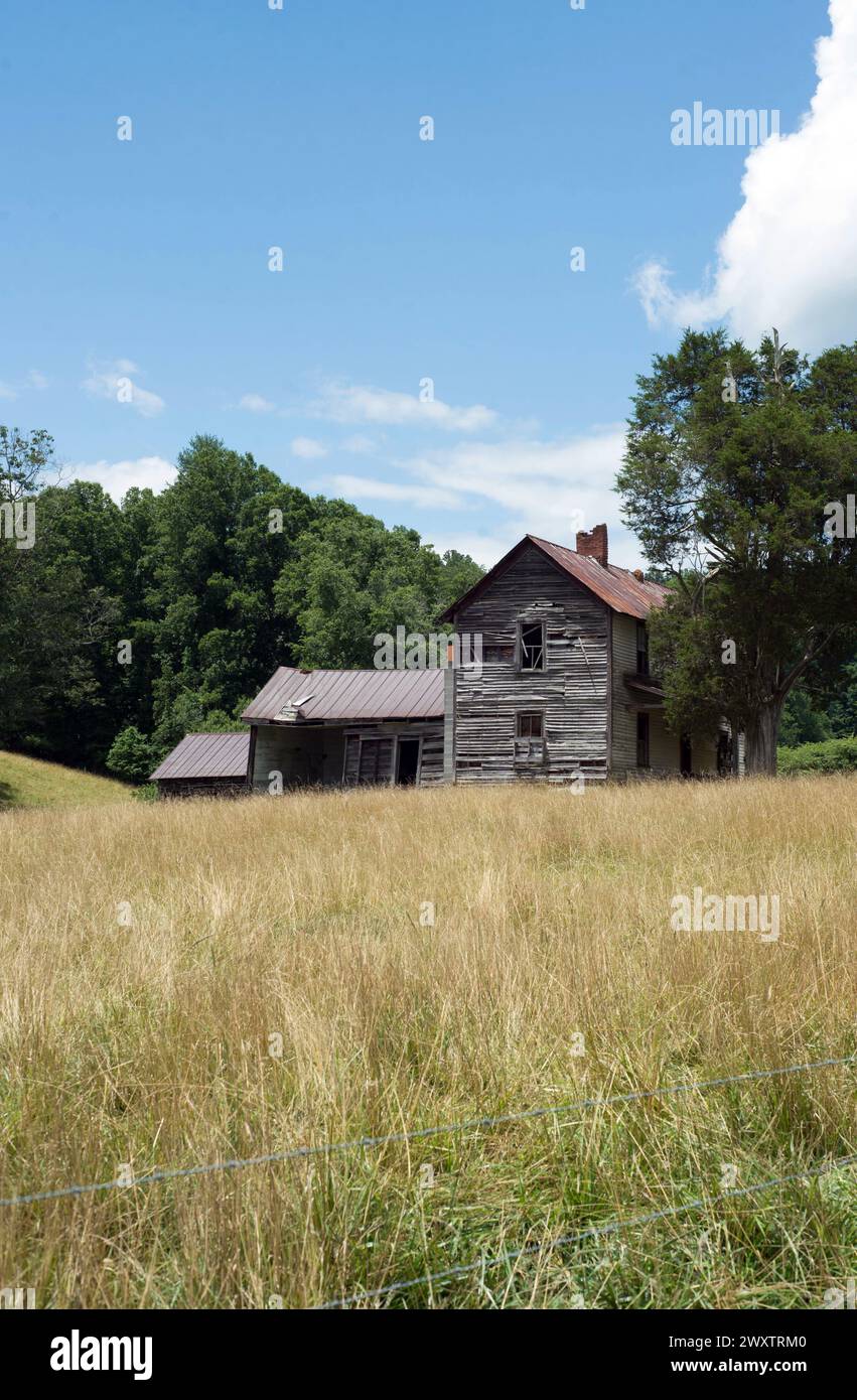Old rustic wooden barn in a field with trees in the background ...