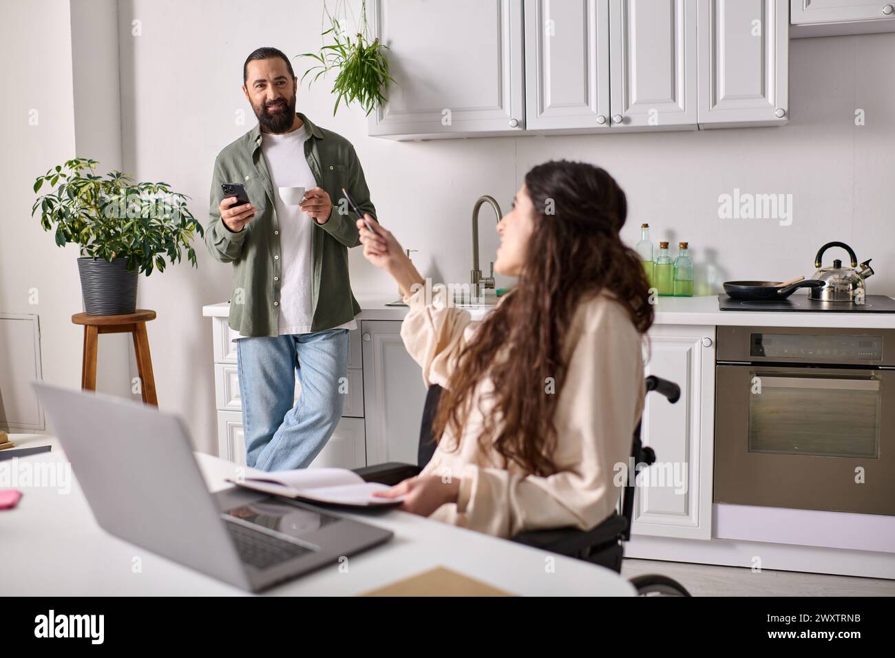 pretty disabled woman in wheelchair working remotely near her husband ...