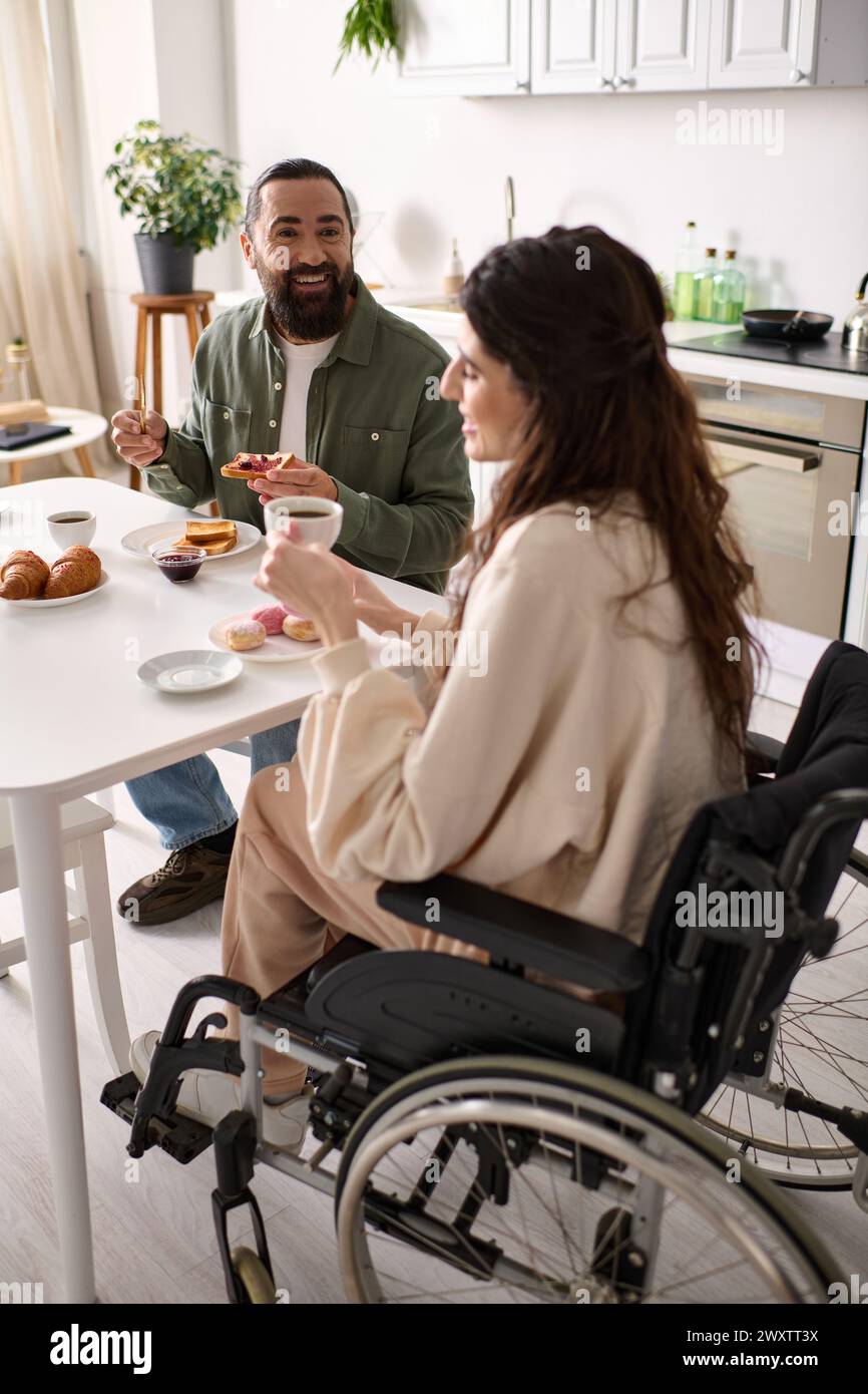 joyful woman with inclusivity in wheelchair eating sweets at breakfast ...