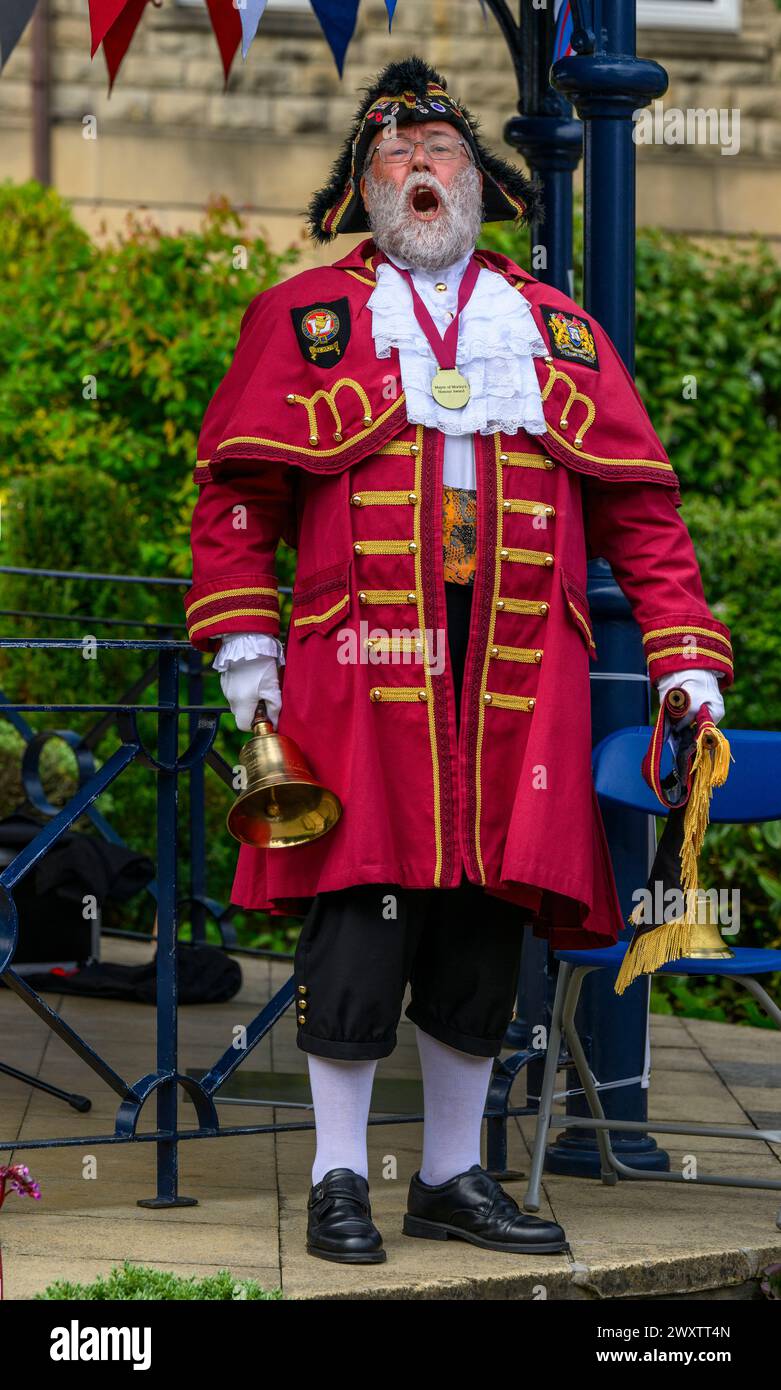 Male town crier (colourful red braided crier's livery) proclaiming ...