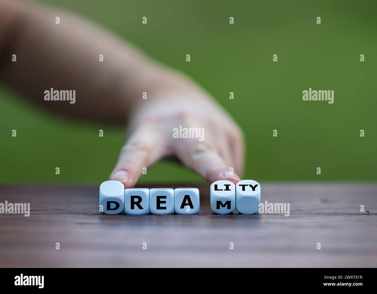 Hand turns dice and changes the word dream to reality Stock Photo - Alamy