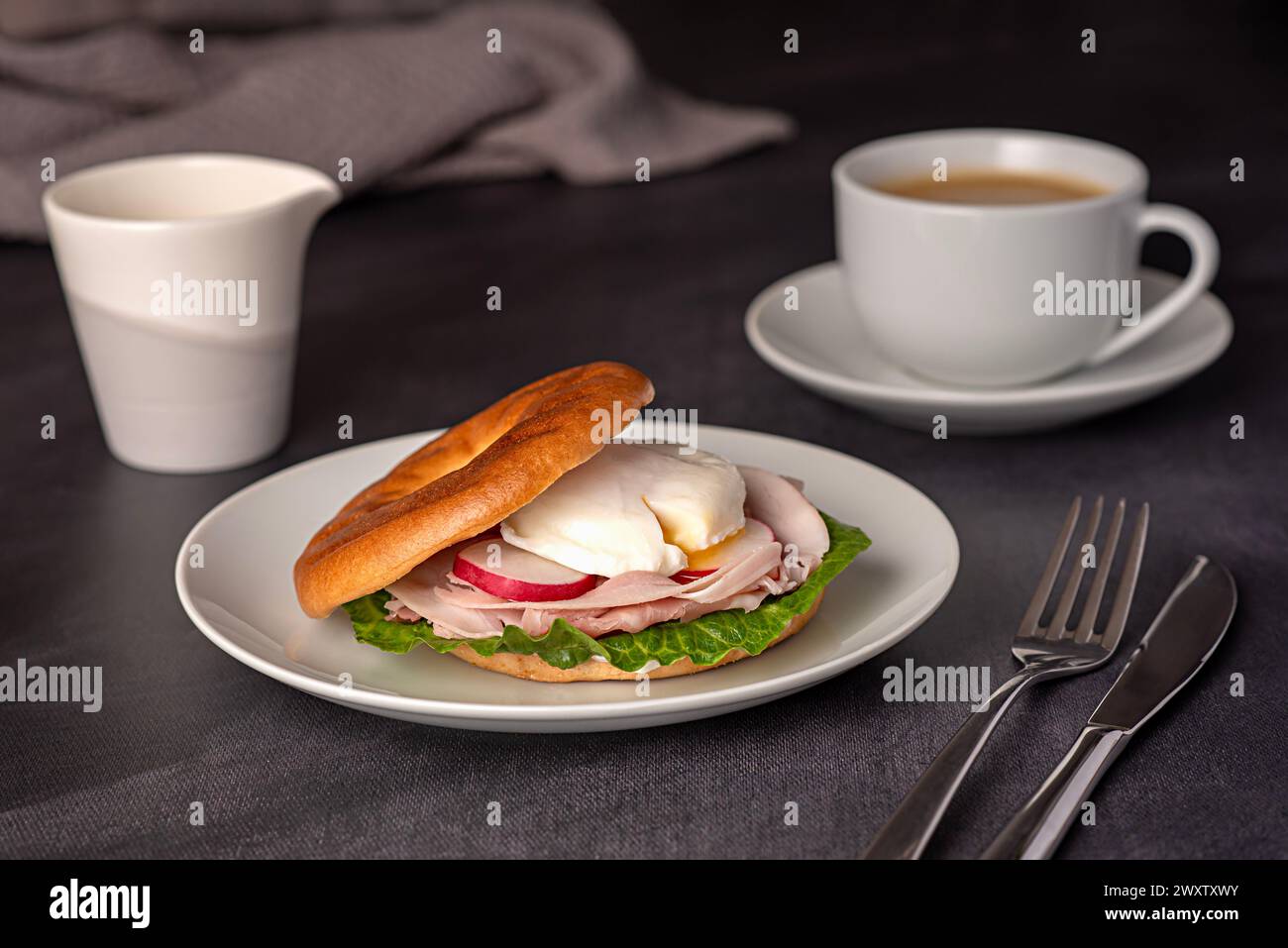 Food photography of bagel with poached egg, radish, bacon, ham, coffee ...