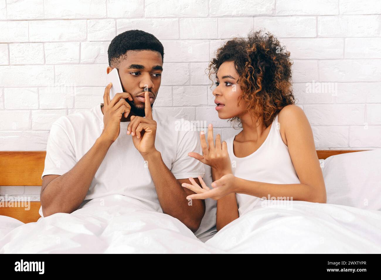Couple arguing with man on phone call Stock Photo - Alamy