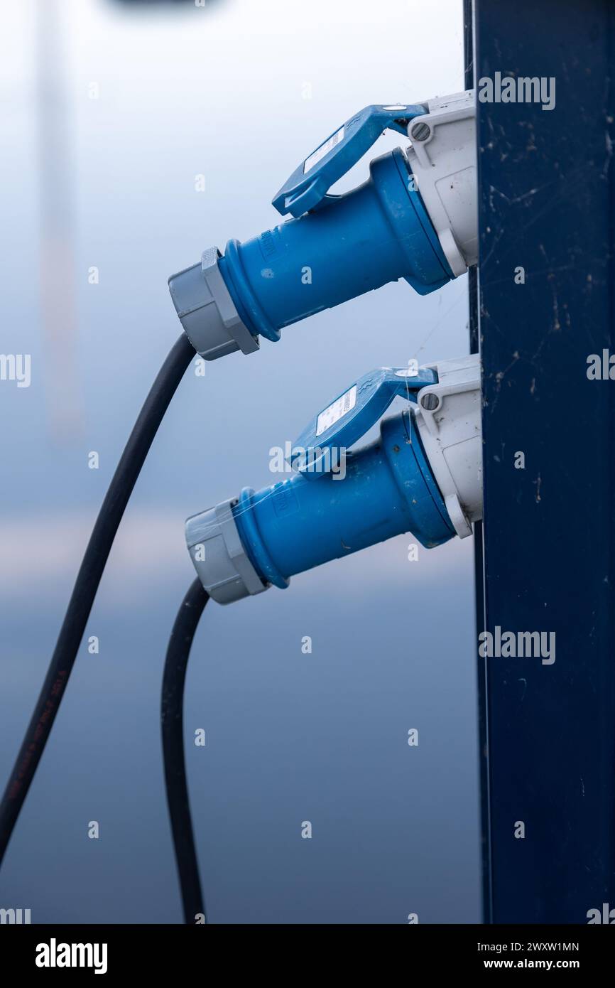 Two CEE (TEC) connectors plugged in to a power supply for charging ...