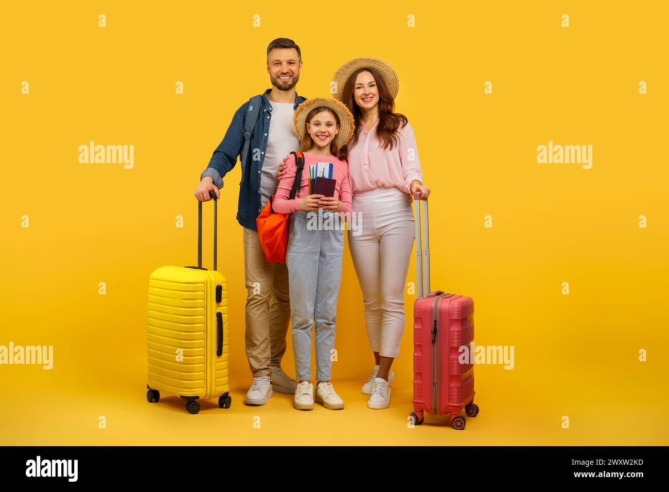 Family ready for vacation with luggage on yellow background Stock Photo ...