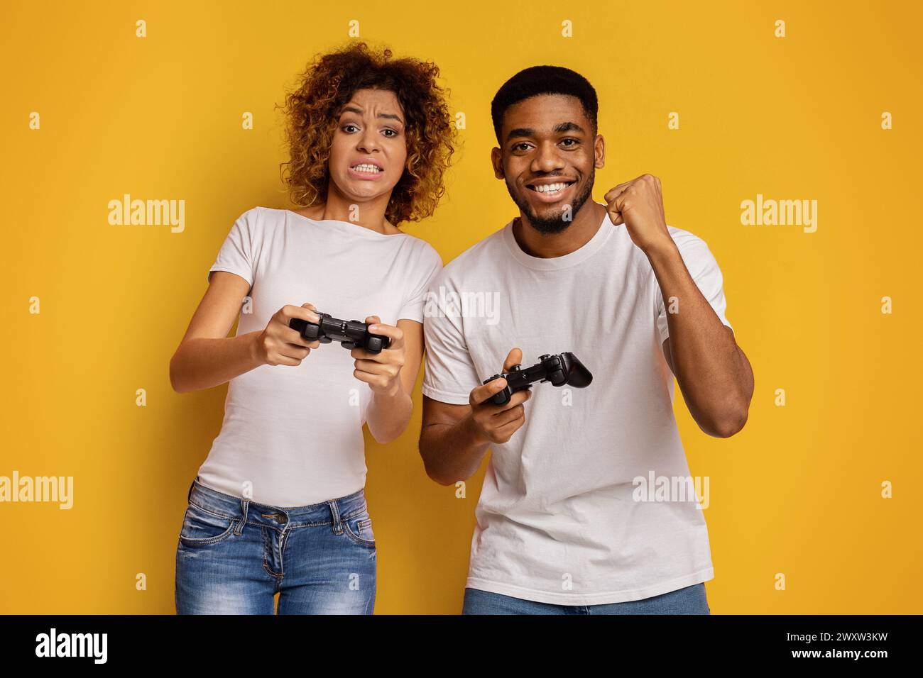 Couple gaming with various reactions on yellow background Stock Photo ...