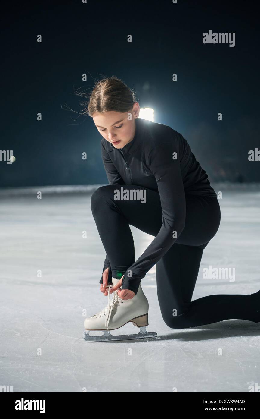 Beautiful young woman ice skating at city ice arena. Winter activities ...