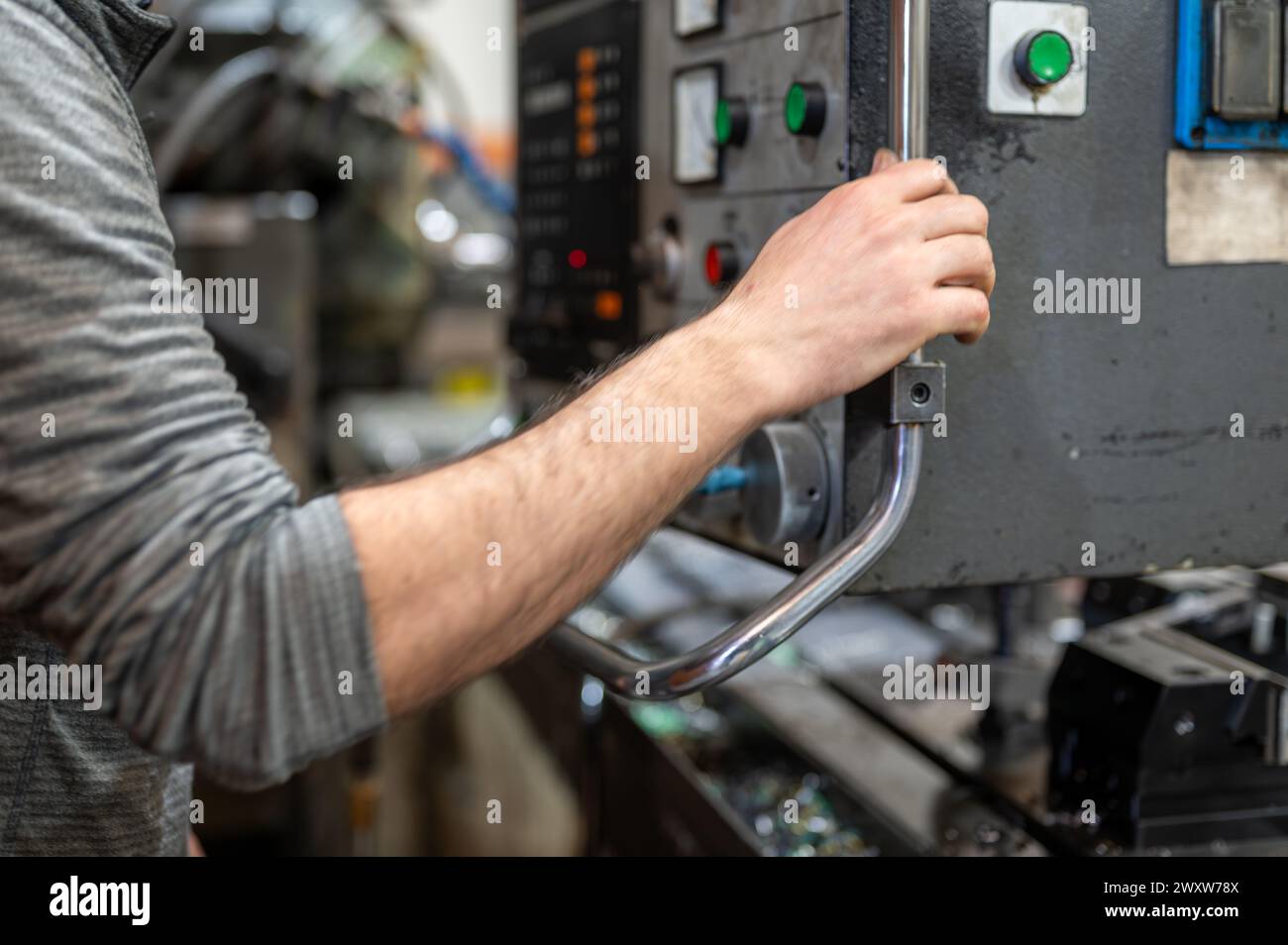 Worker pressing buttons on CNC machine control board in factory. High ...