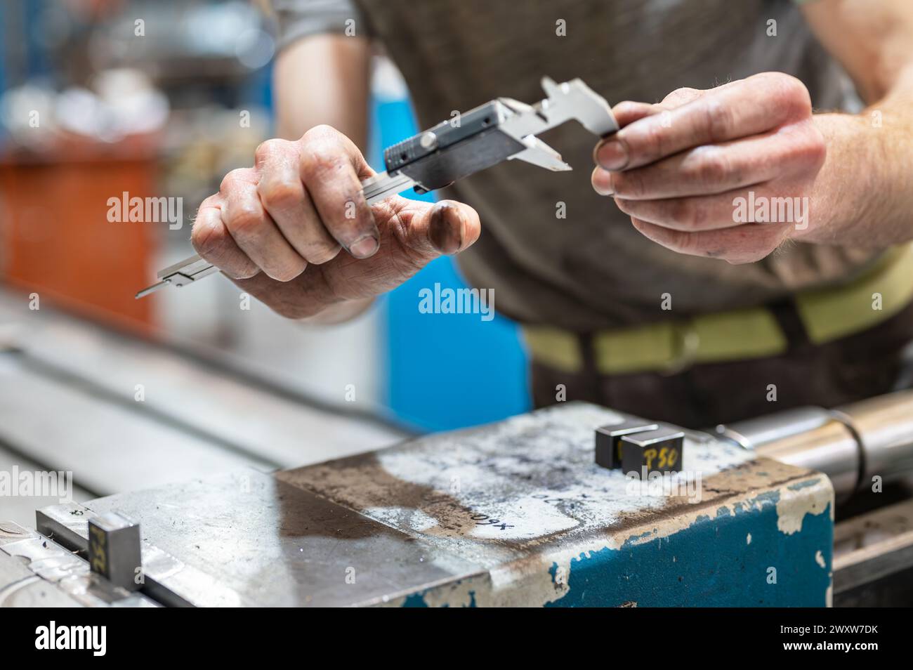 Professional metalworker using a caliber at the manufacture workshop ...