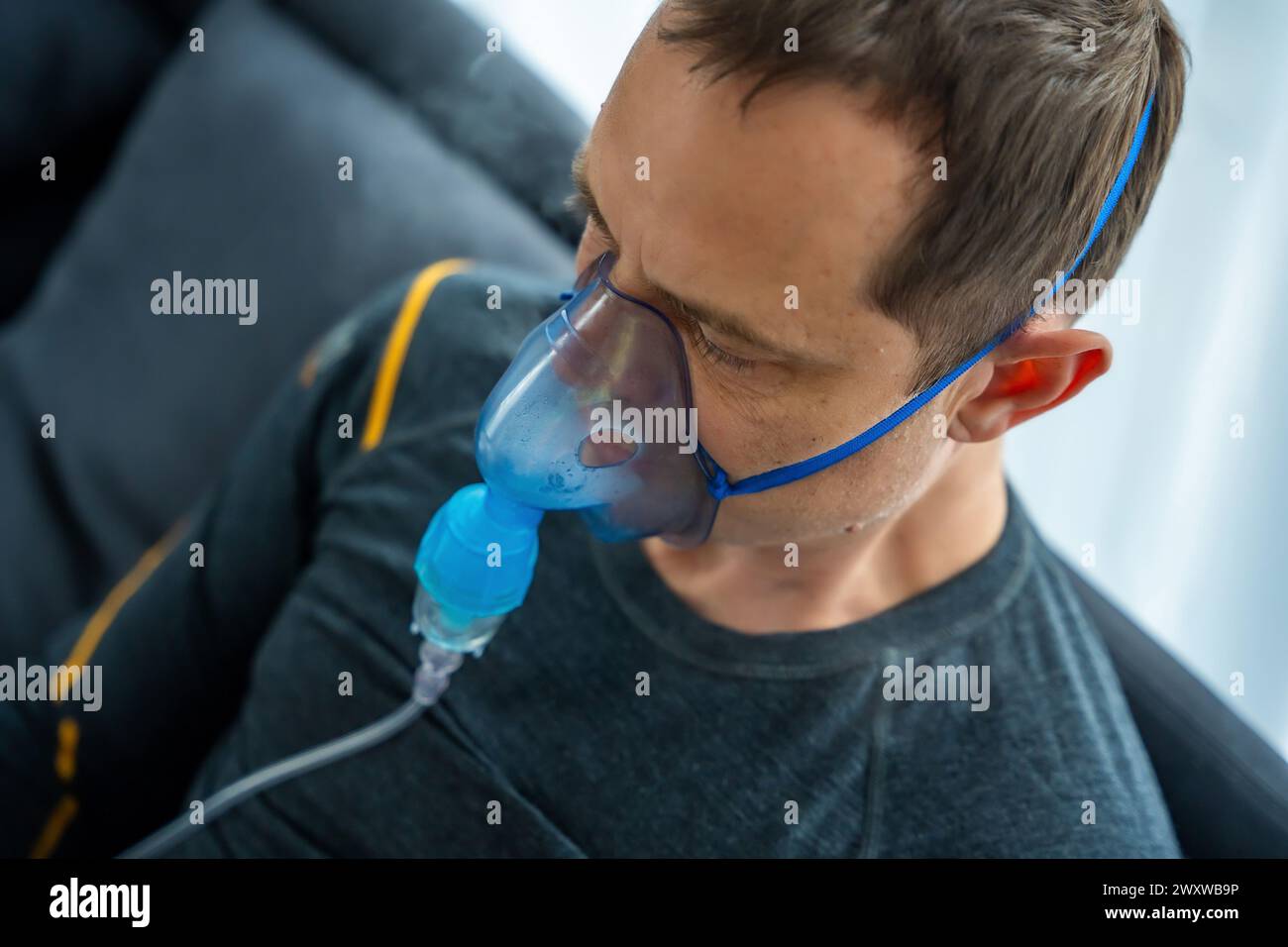 Unhealthy man wearing nebulizer mask in home. Health, medical equipment ...