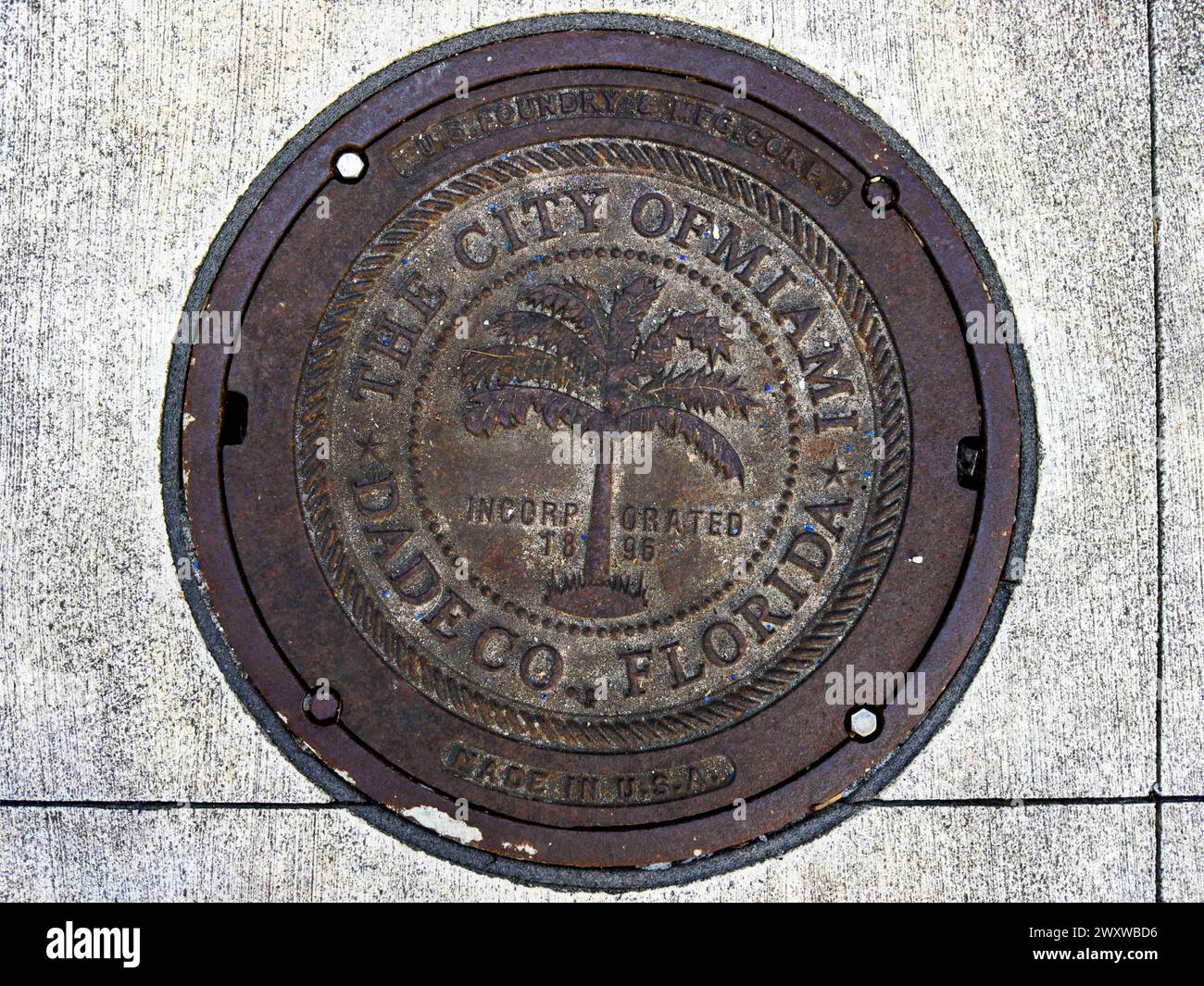Steel manhole cover of the logo of a palm tree of the City of Miali ...