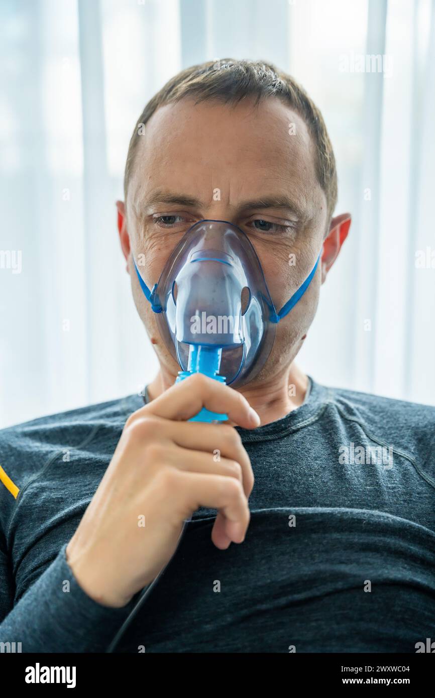 Unhealthy man wearing nebulizer mask in home. Health, medical equipment ...