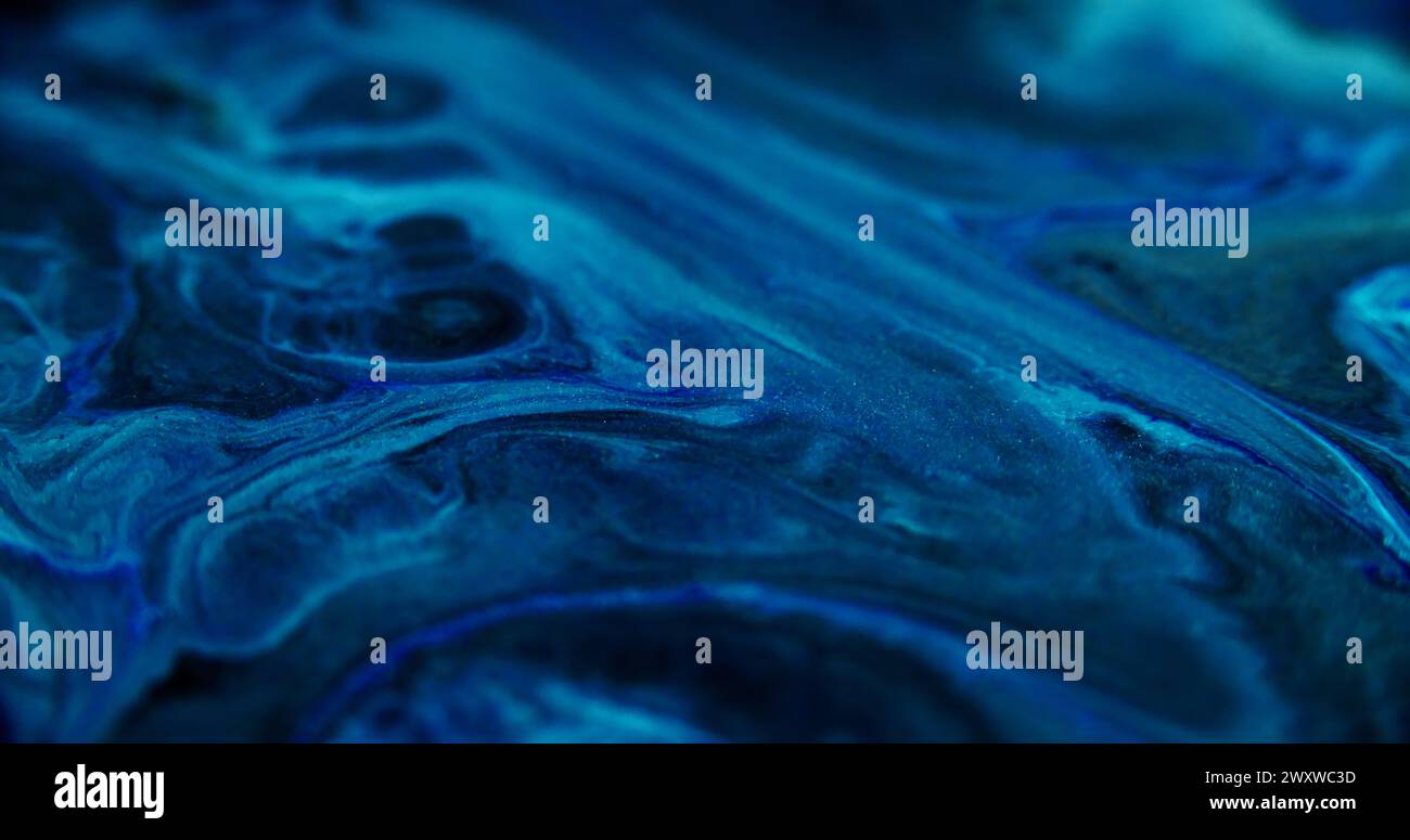 Glitter liquid spill. Acrylic paint mix. Defocused blue black color ...