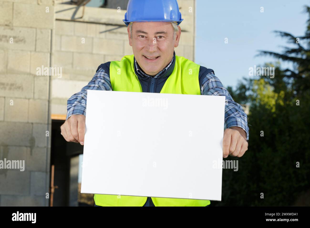senior workman holding blank sign Stock Photo - Alamy