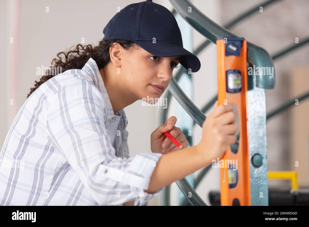 female builder checking staircase railing with spirit level Stock Photo ...