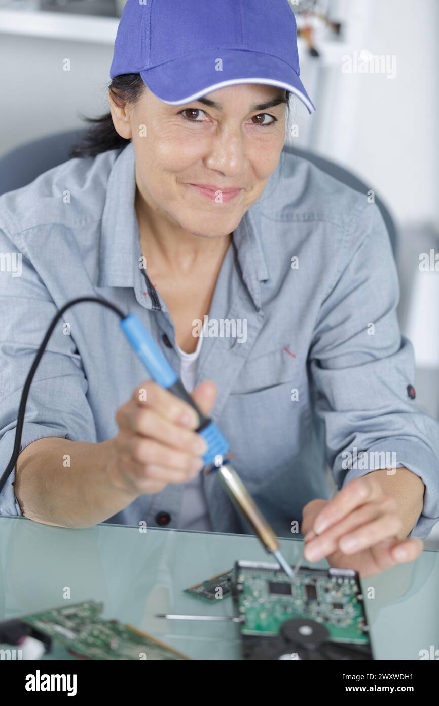 woman electronic engineer repairing soldering computer pc motherboard ...