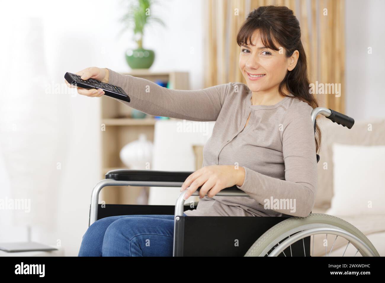 Woman pressing remote control hi-res stock photography and images - Alamy
