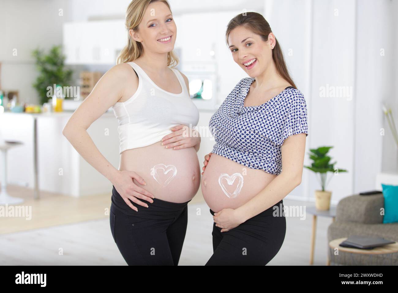 two pregnant friends showing their baby bumps Stock Photo - Alamy